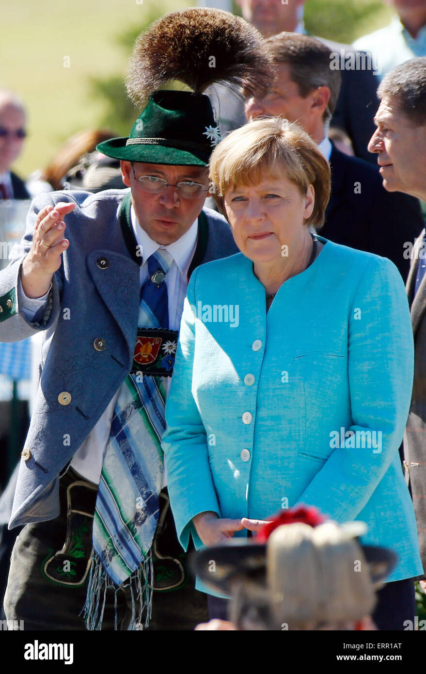 German Chancellor Angela Merkel talks to man dressed in traditional ...