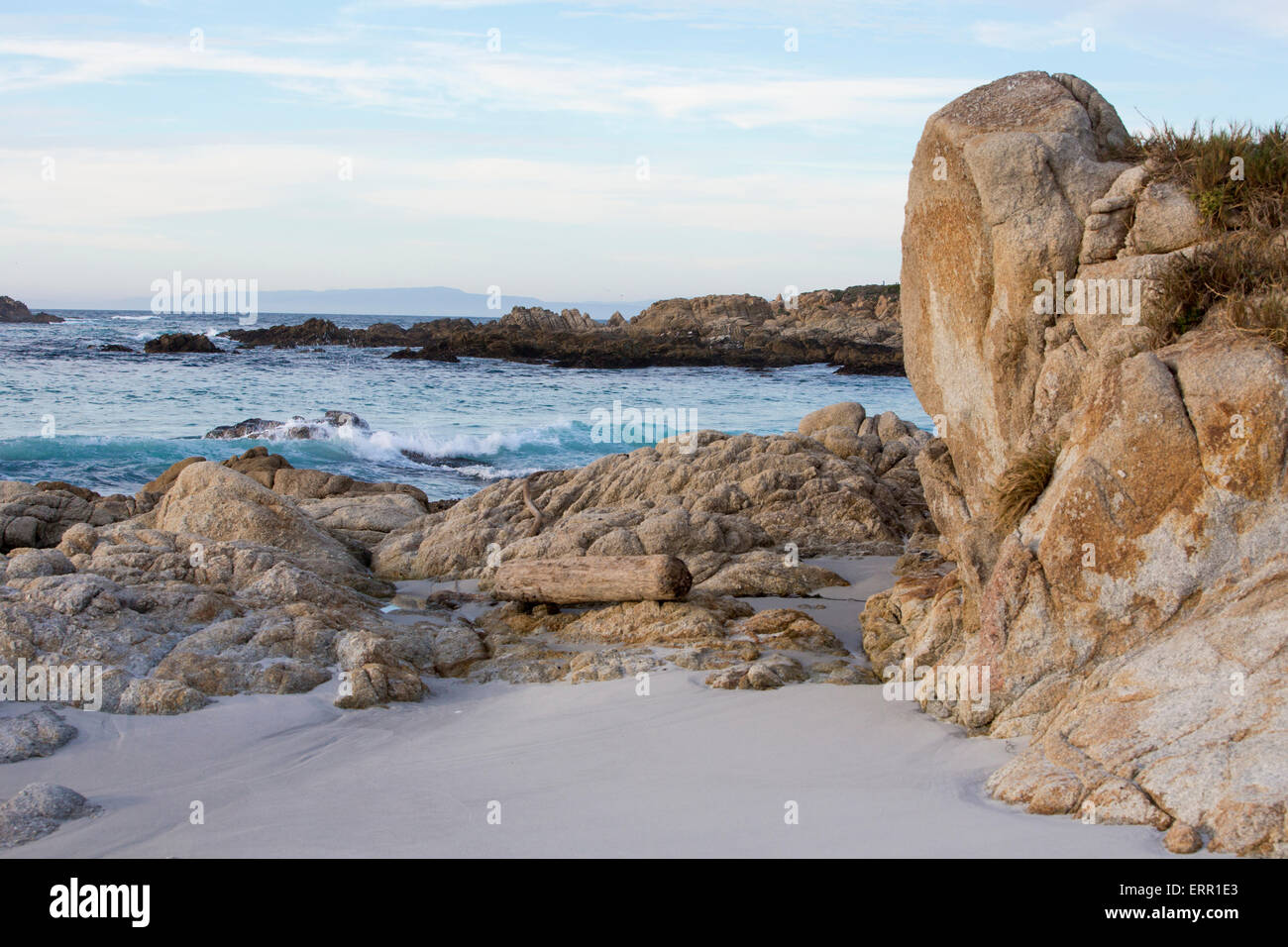 beautiful sand beach with beige rocks and blue waves Stock Photo - Alamy
