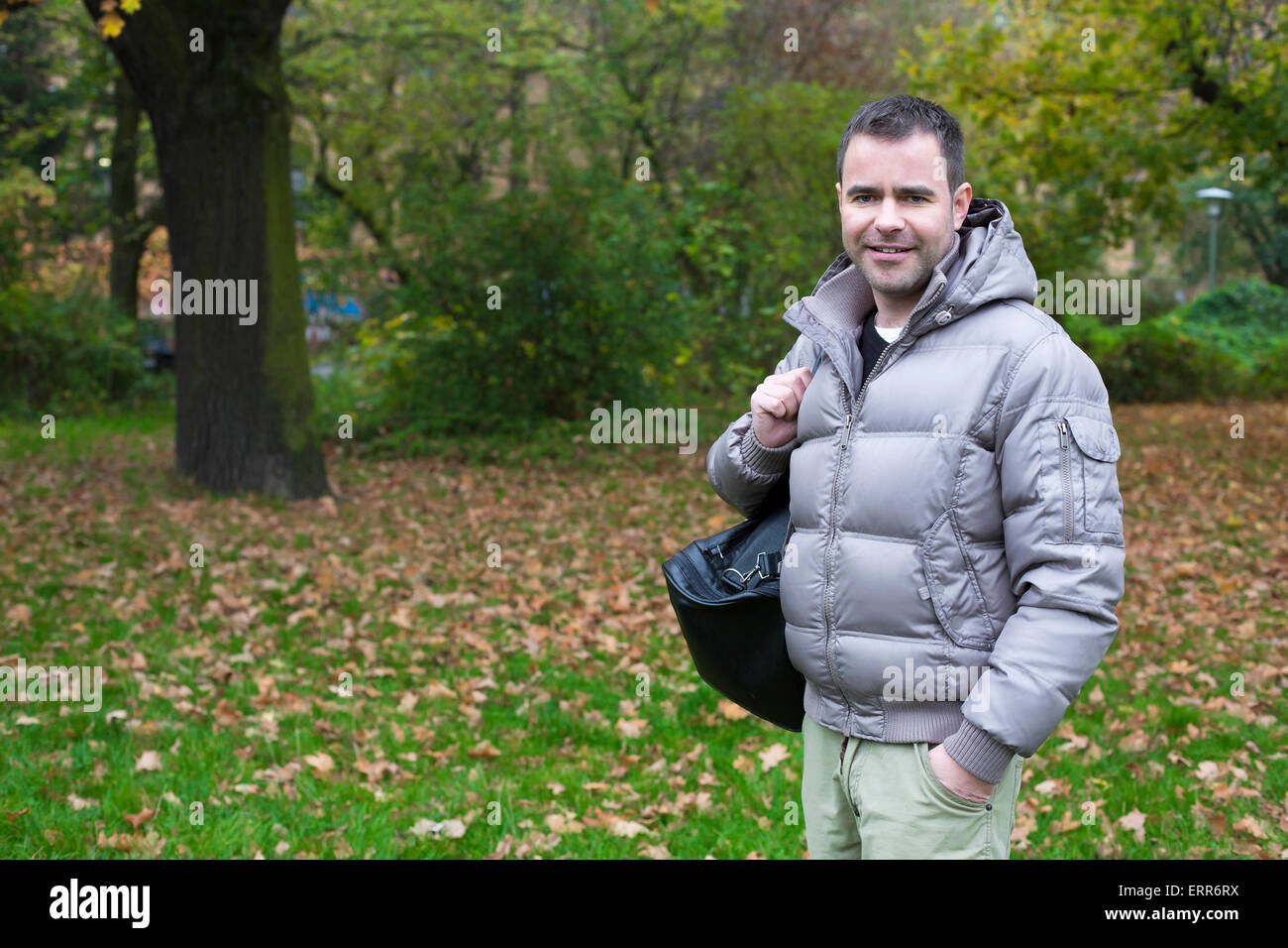a handsome man standing in a park Stock Photo - Alamy