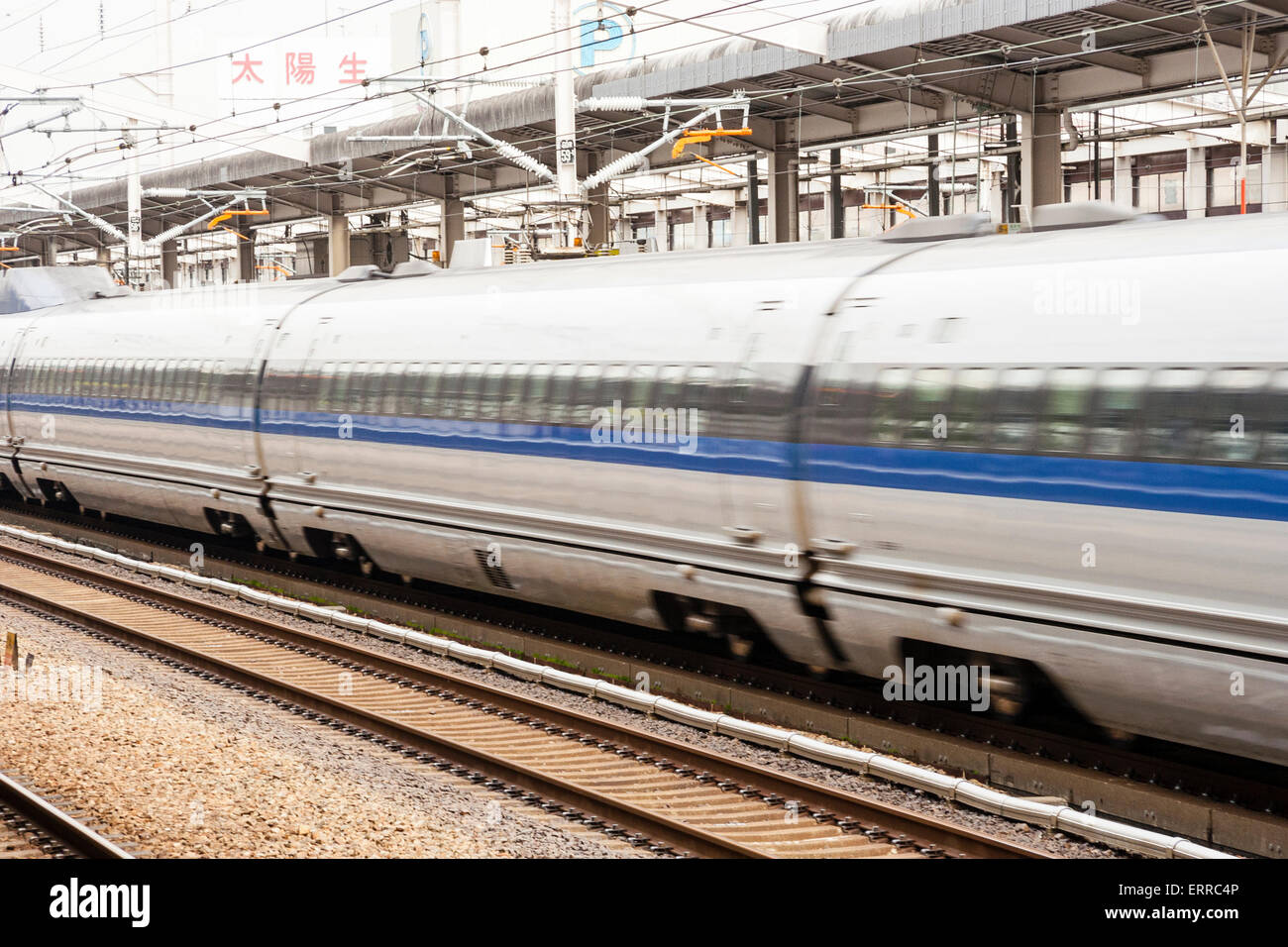 A Japanese 500 series Shinkansen, Nozomi bullet train, passing through a station at full speed ...
