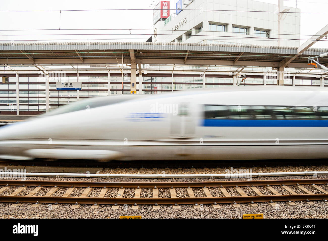 A Japanese 500 series Shinkansen, Nozomi bullet train, passing through a station at full speed ...