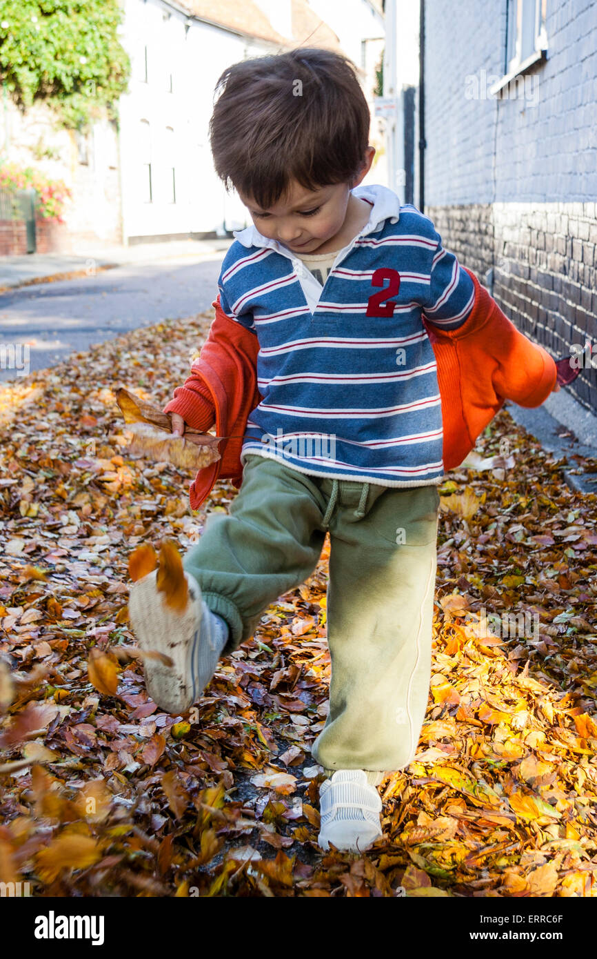 Caucasian child, boy, 4-5 year old, walking along street covered in ...