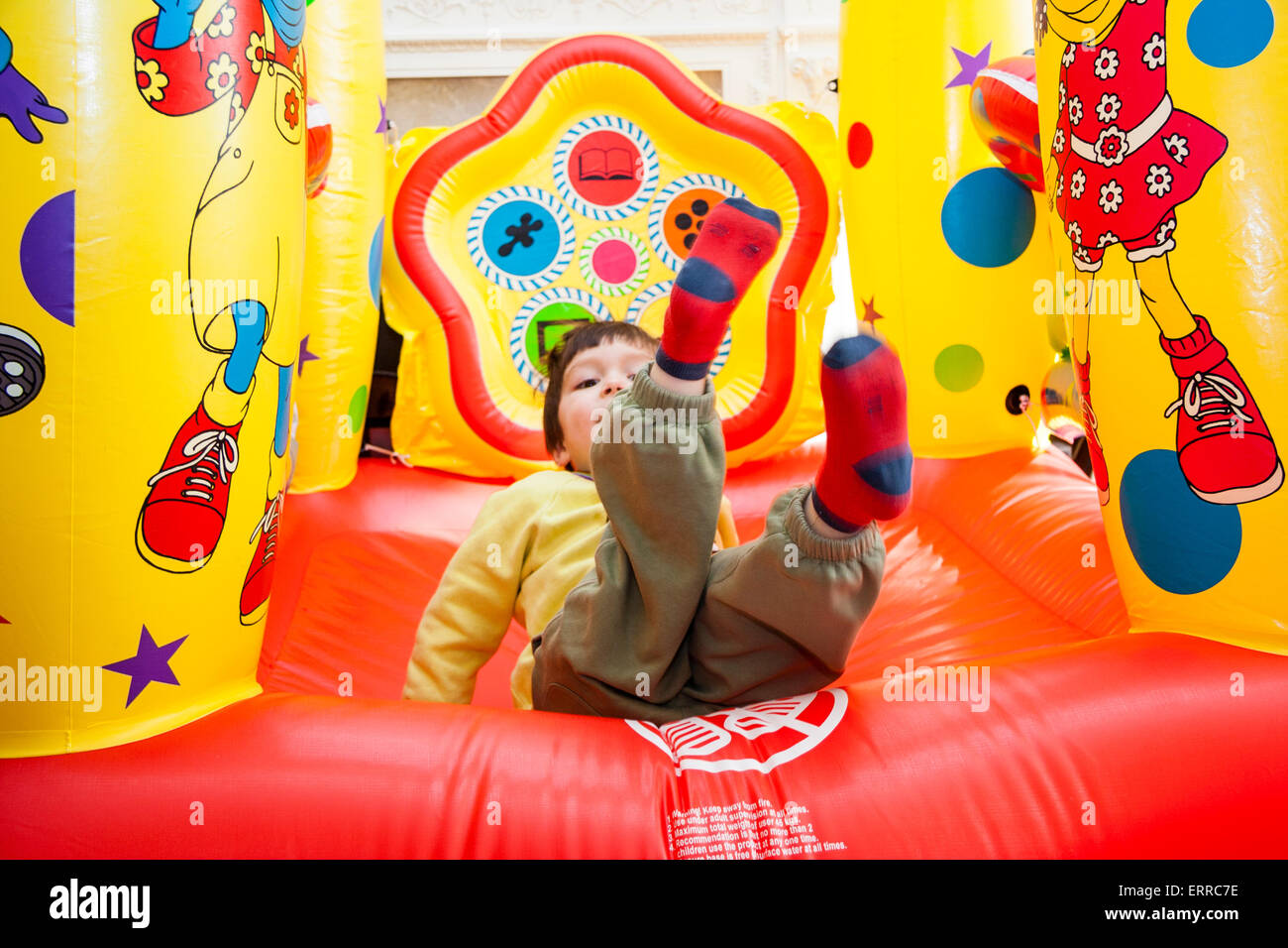 Caucasian child, boy, 4-5 year old, playing indoors on a bright red and ...