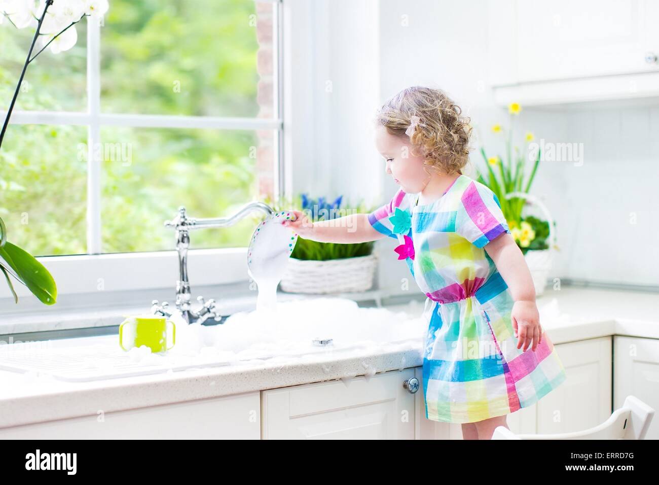 Child washing dishes. Kids wash plates and cups. Little girl helping in ...