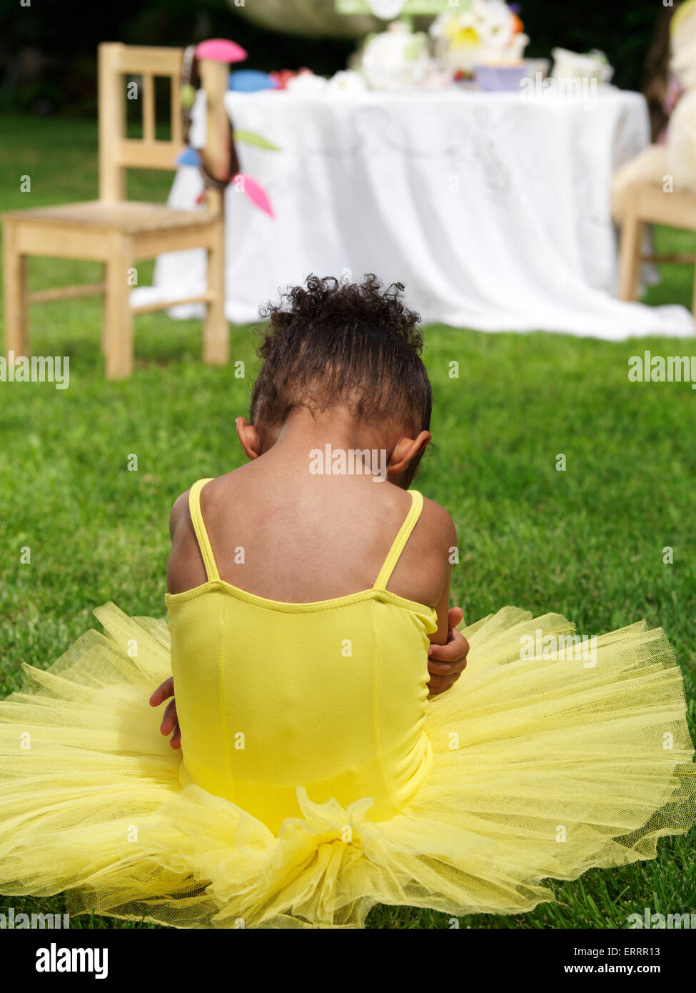 Portrait of a sad little african-american girl in a yellow tutu dress ...