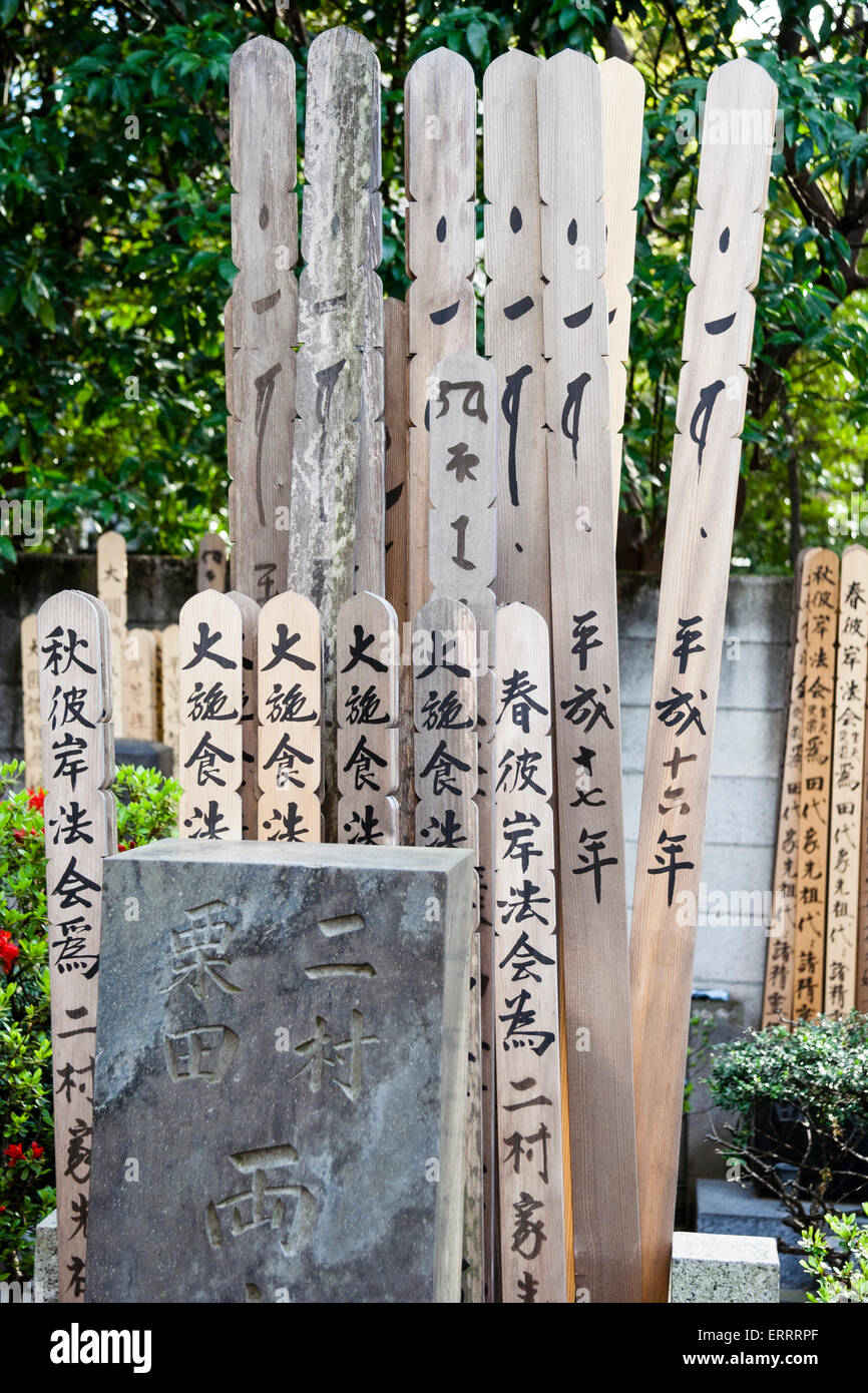 Graveyard, cemetery in Tokyo, gravestone with wooden memorial sticks ...