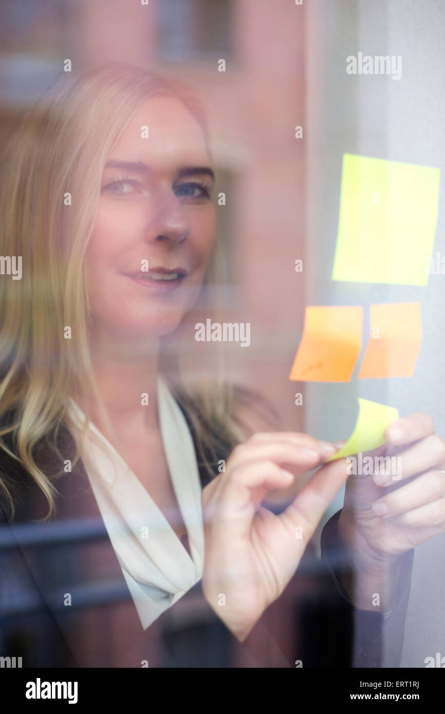 blond woman looking at notes by the window Stock Photo - Alamy