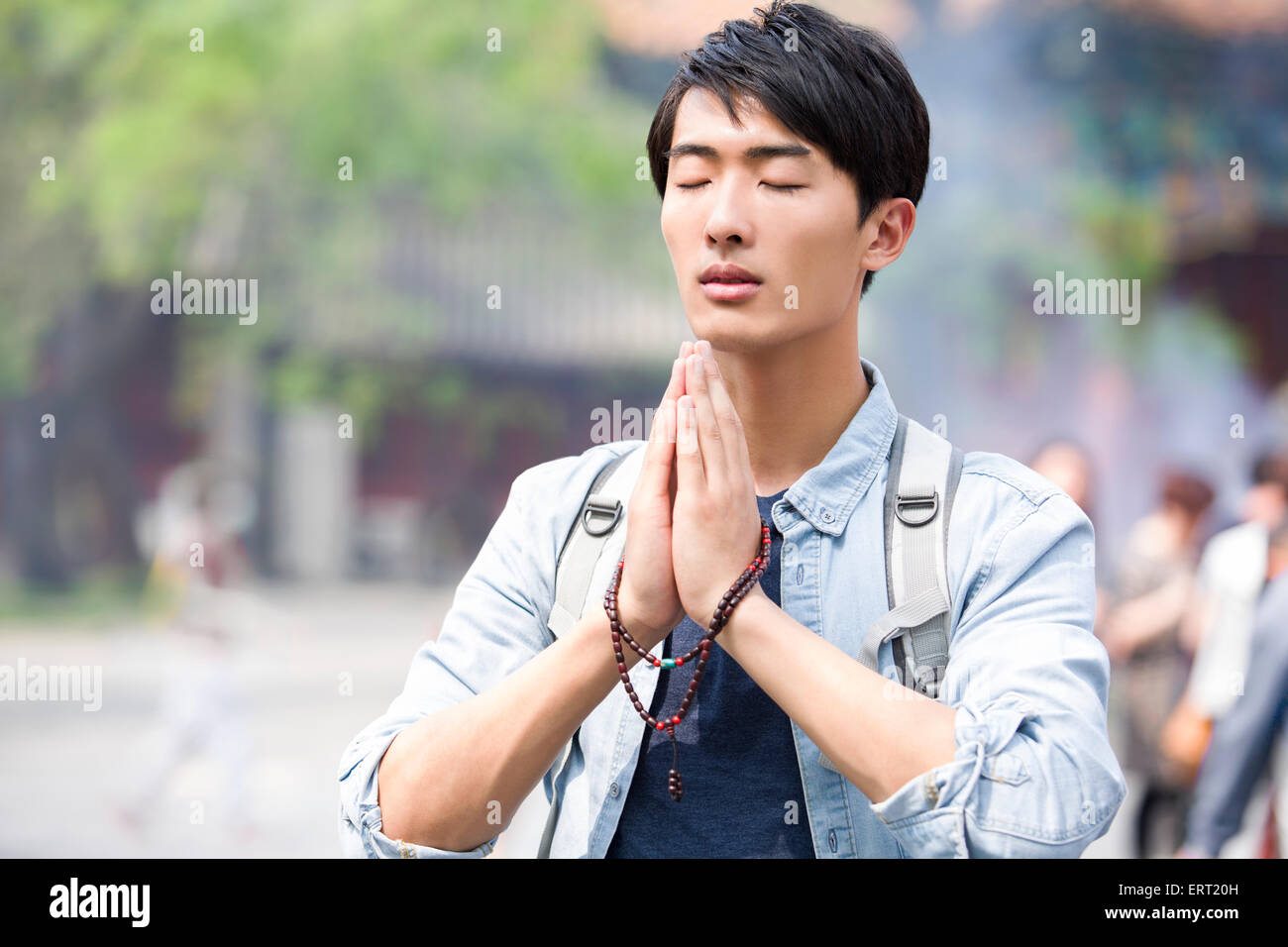 Young man praying in the Lama Temple Stock Photo - Alamy