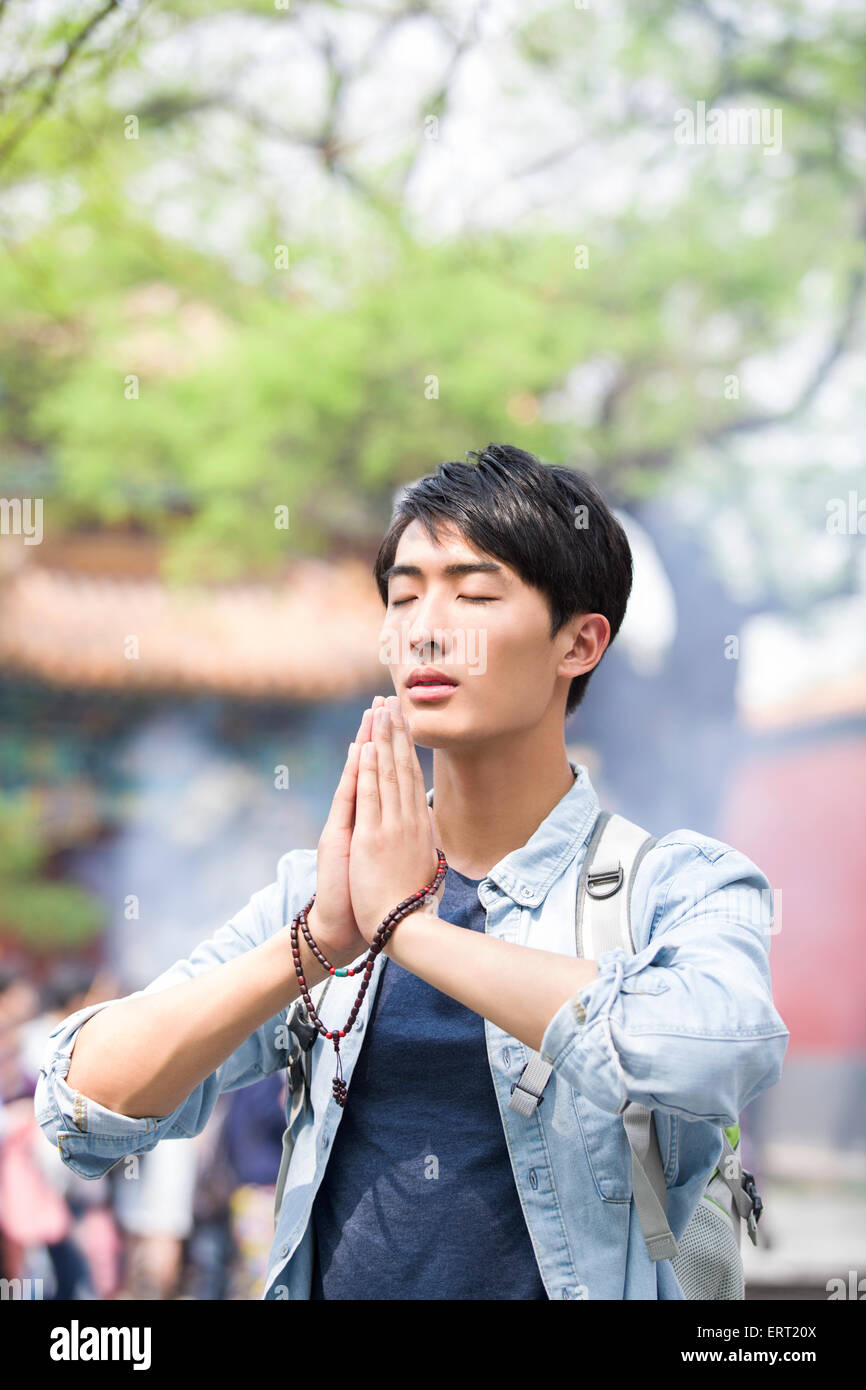 Young man praying in the Lama Temple Stock Photo - Alamy