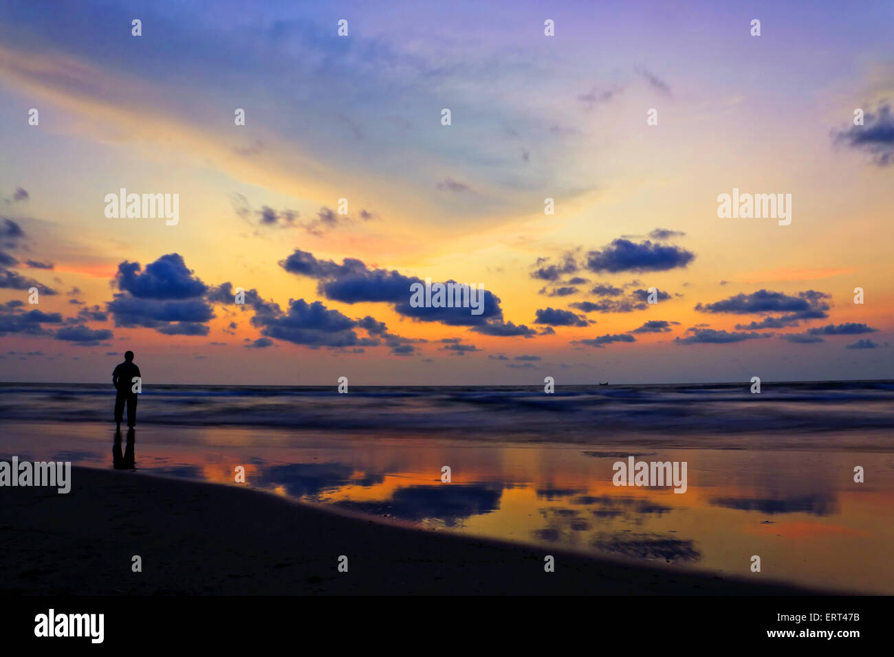 Man standing on a Beach at Sunset Stock Photo - Alamy