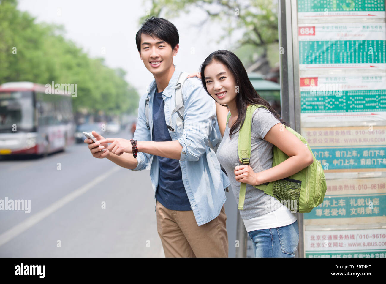 Young couple waiting at the bus stop Stock Photo - Alamy