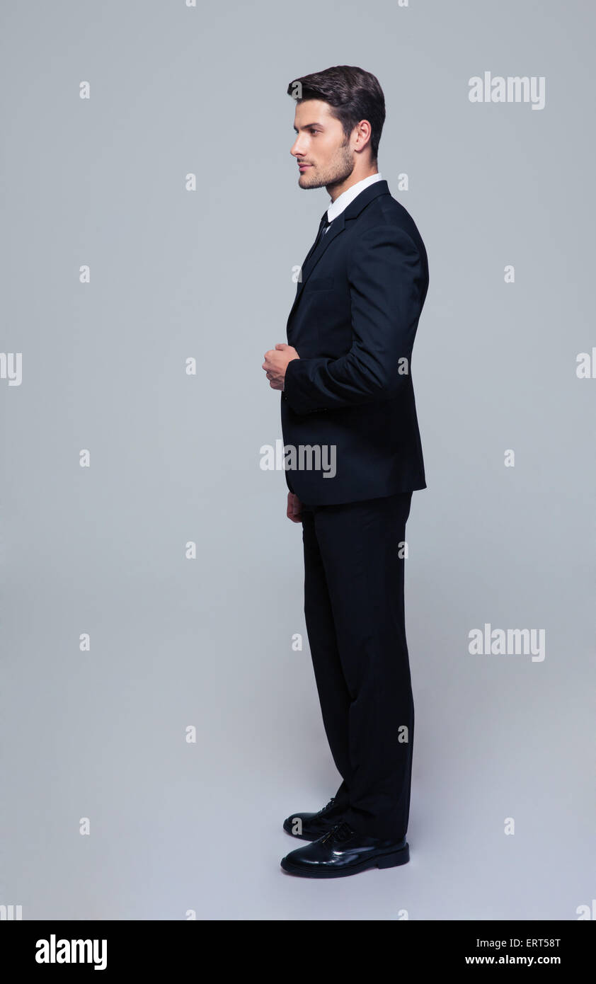 Side view portrait of a confident businessman standing over gray ...