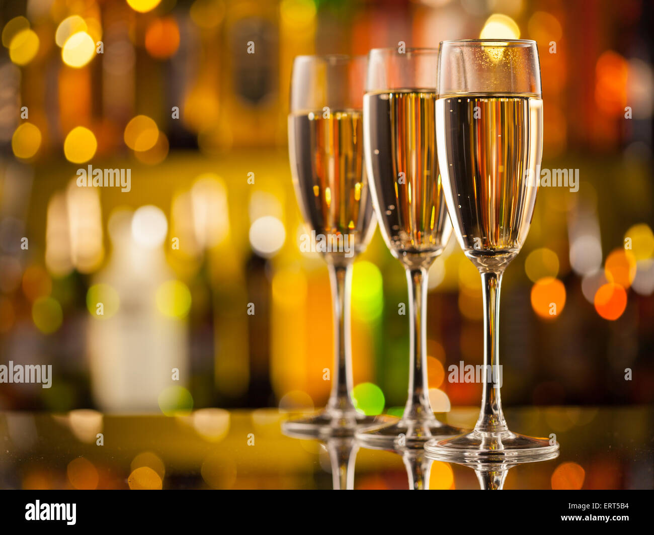 Celebration theme with three glasses of champagne. Blur bottles on ...