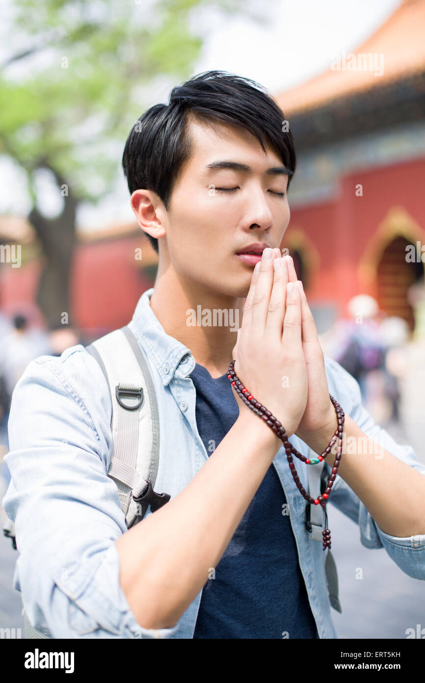 Young man praying in the Lama Temple Stock Photo - Alamy