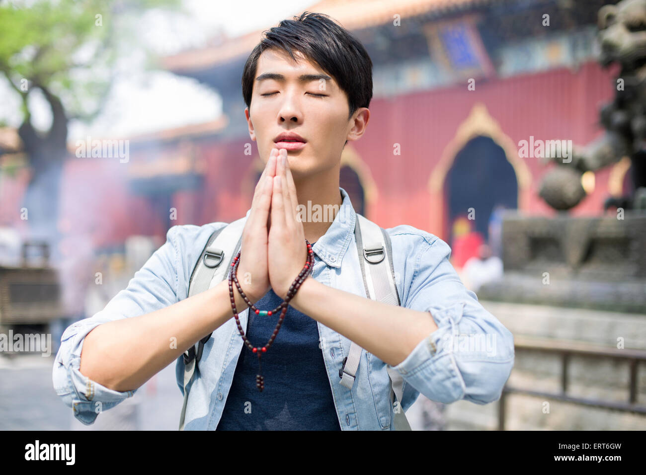 Young man praying in the Lama Temple Stock Photo - Alamy