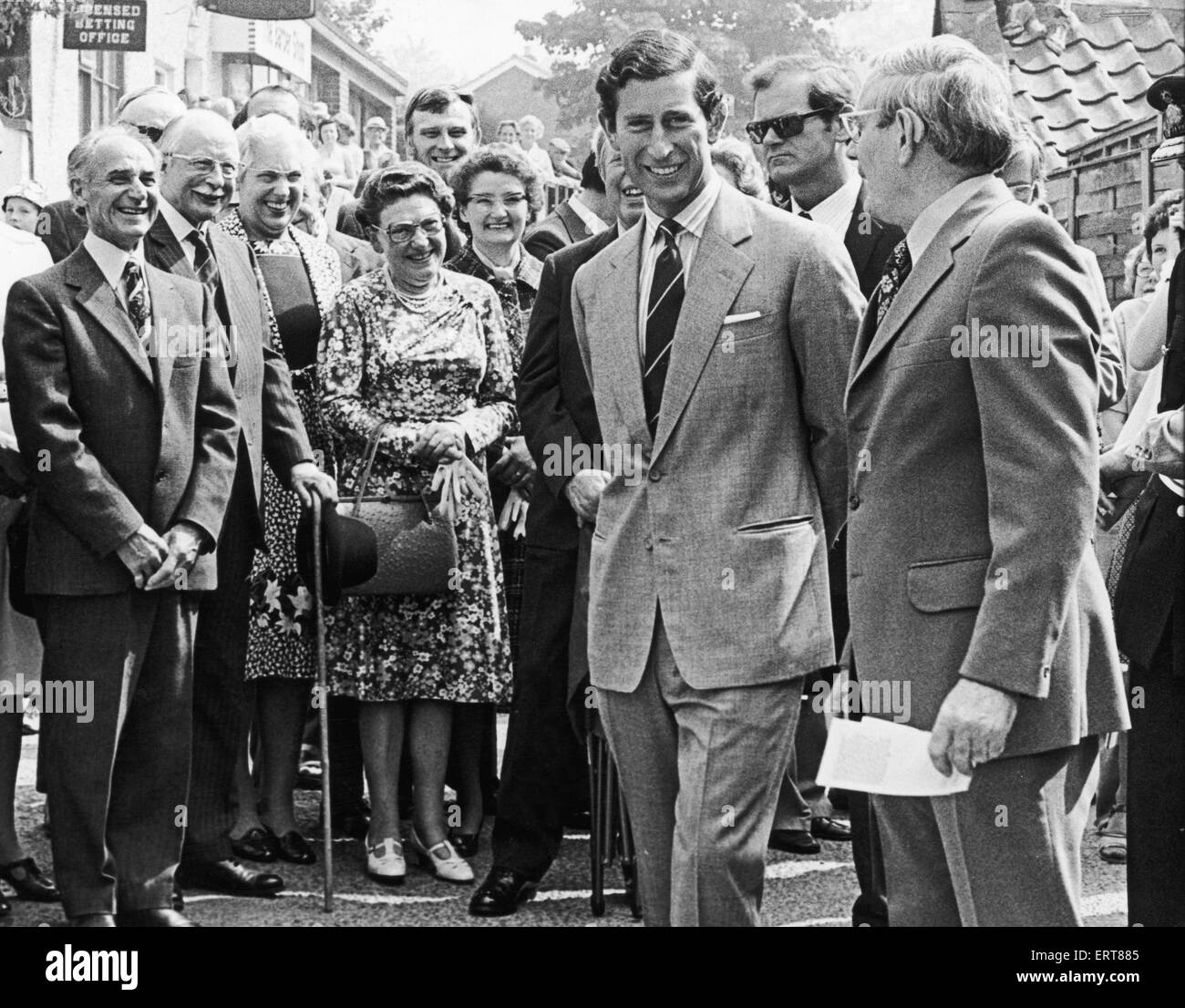 A smiling Prince Charles talks to villagers as he walks around the ...