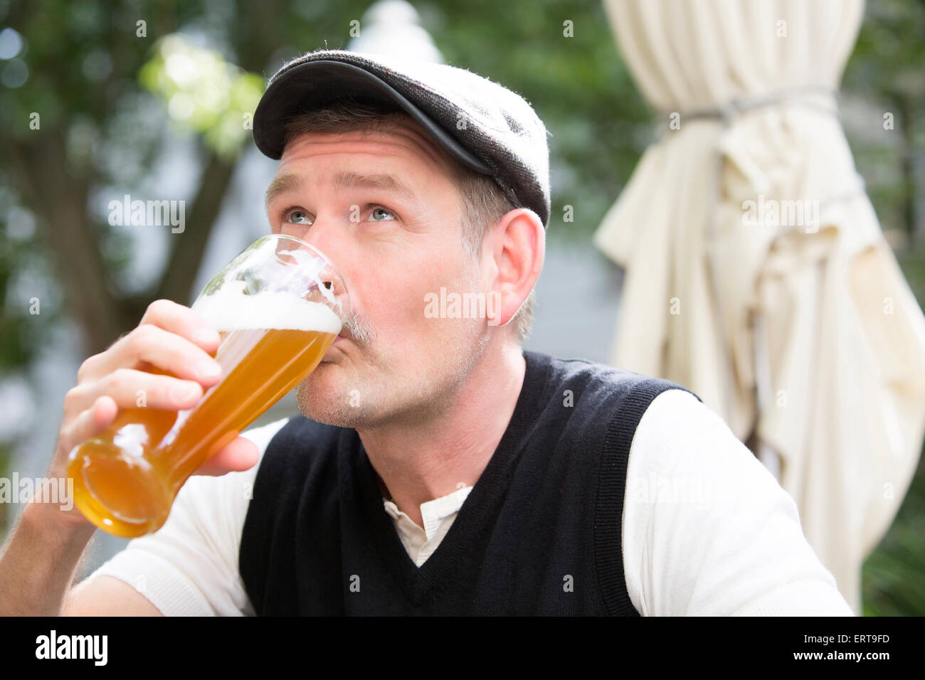 man sitting outside and drinking beer Stock Photo - Alamy