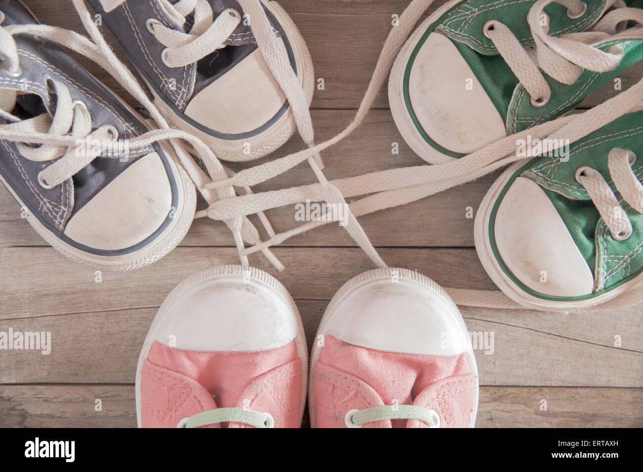 Picture of a three child shoes on a wooden floor Stock Photo - Alamy