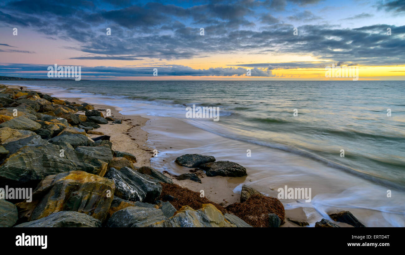 Sunset above sea on a rocky beach. Long exposure effect Stock Photo - Alamy