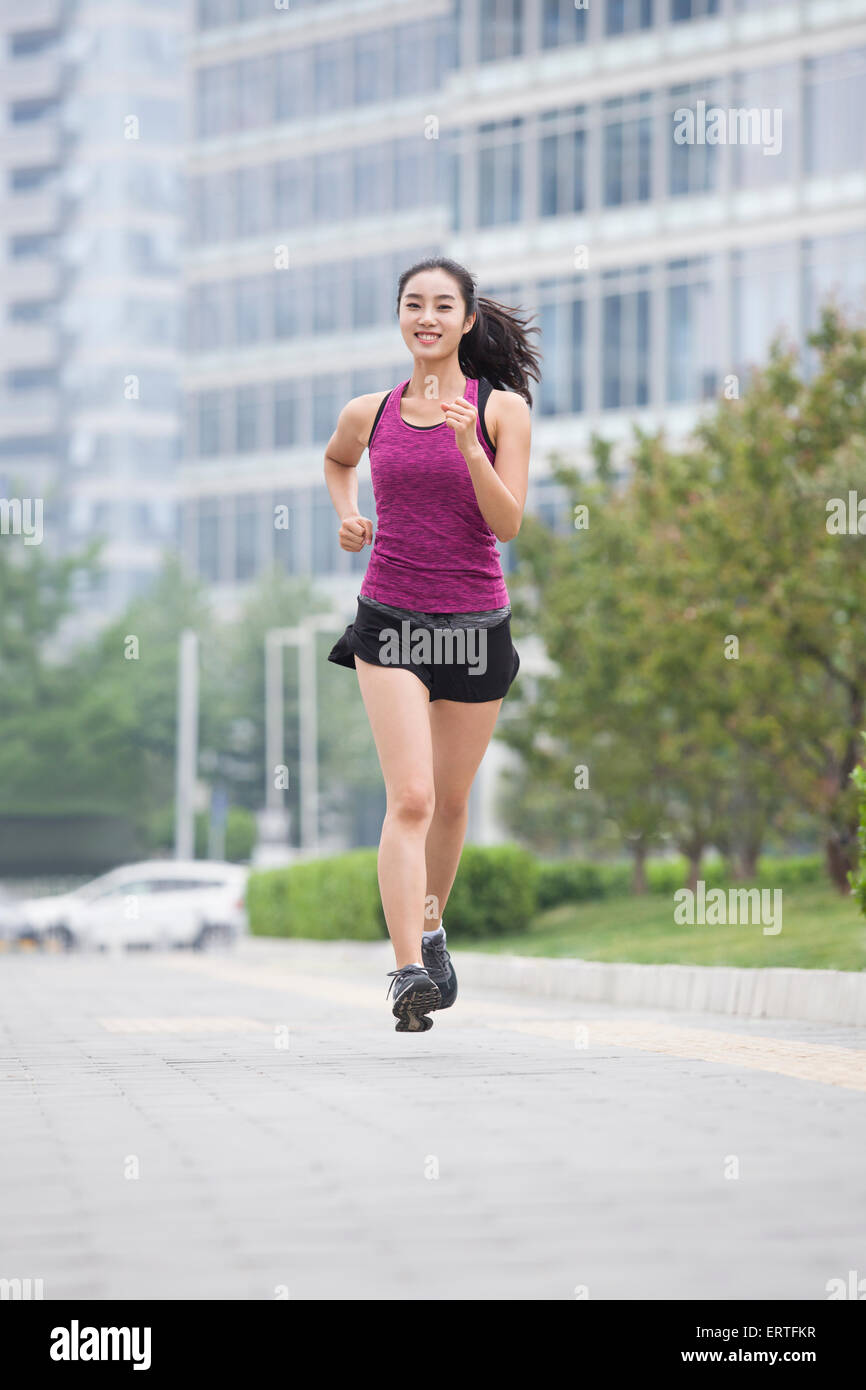Young woman running outside Stock Photo - Alamy