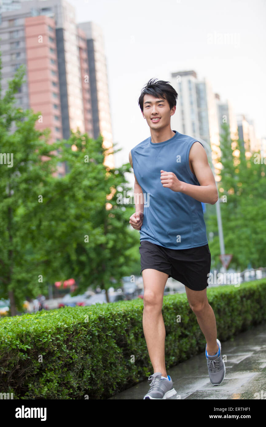 Young man running outside Stock Photo - Alamy