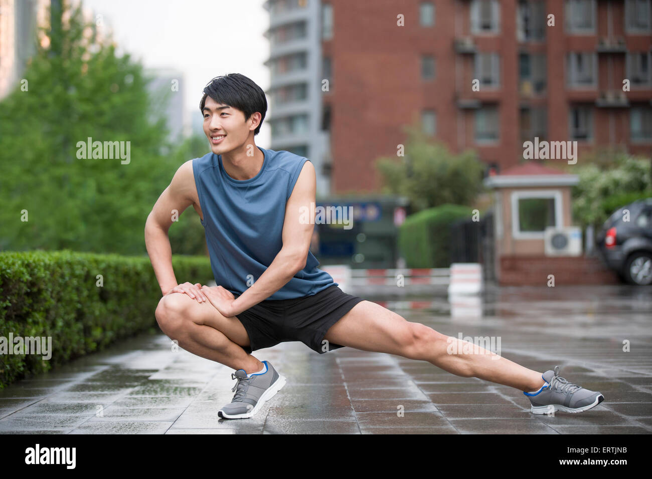 Young man stretching leg outside Stock Photo - Alamy