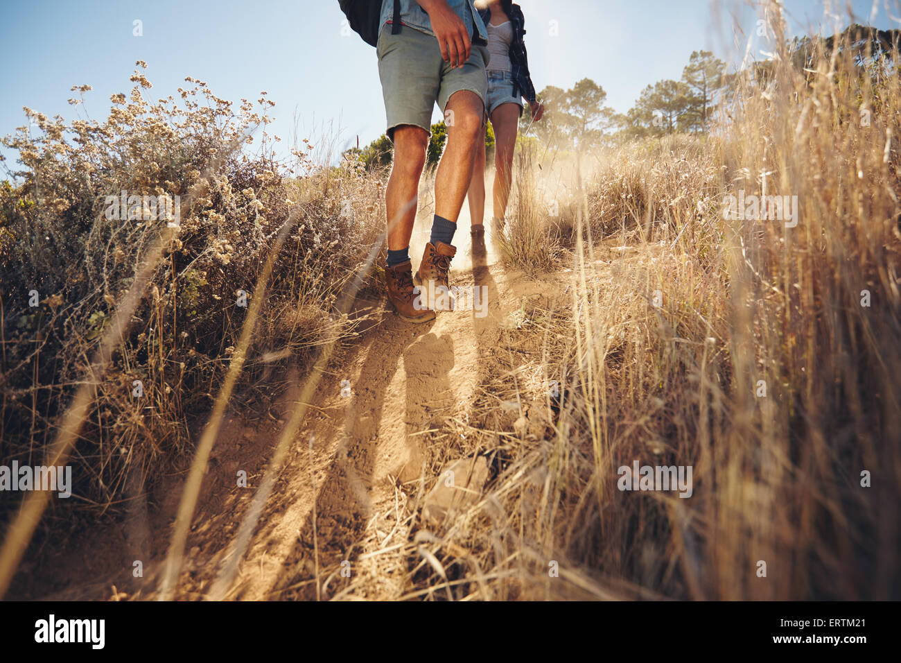 Low angle view of young couple walking on country trail path. Couple ...