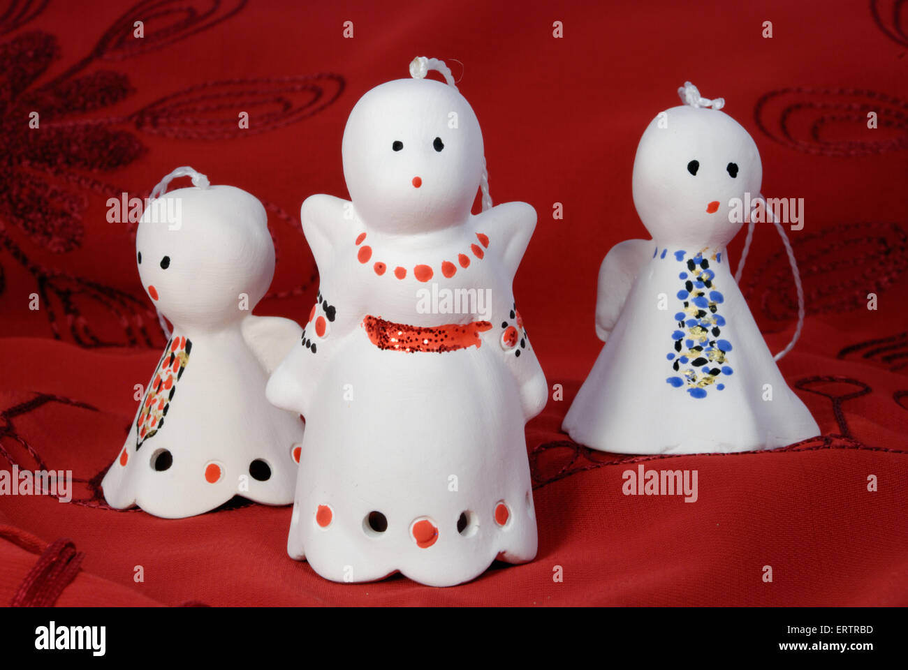 Angels family made of ceramics on a red cloth Stock Photo - Alamy