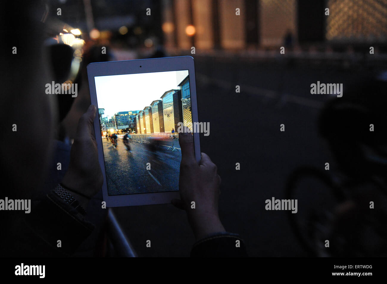 Spectator photographing the elite mens cycling race at Smithfield ...