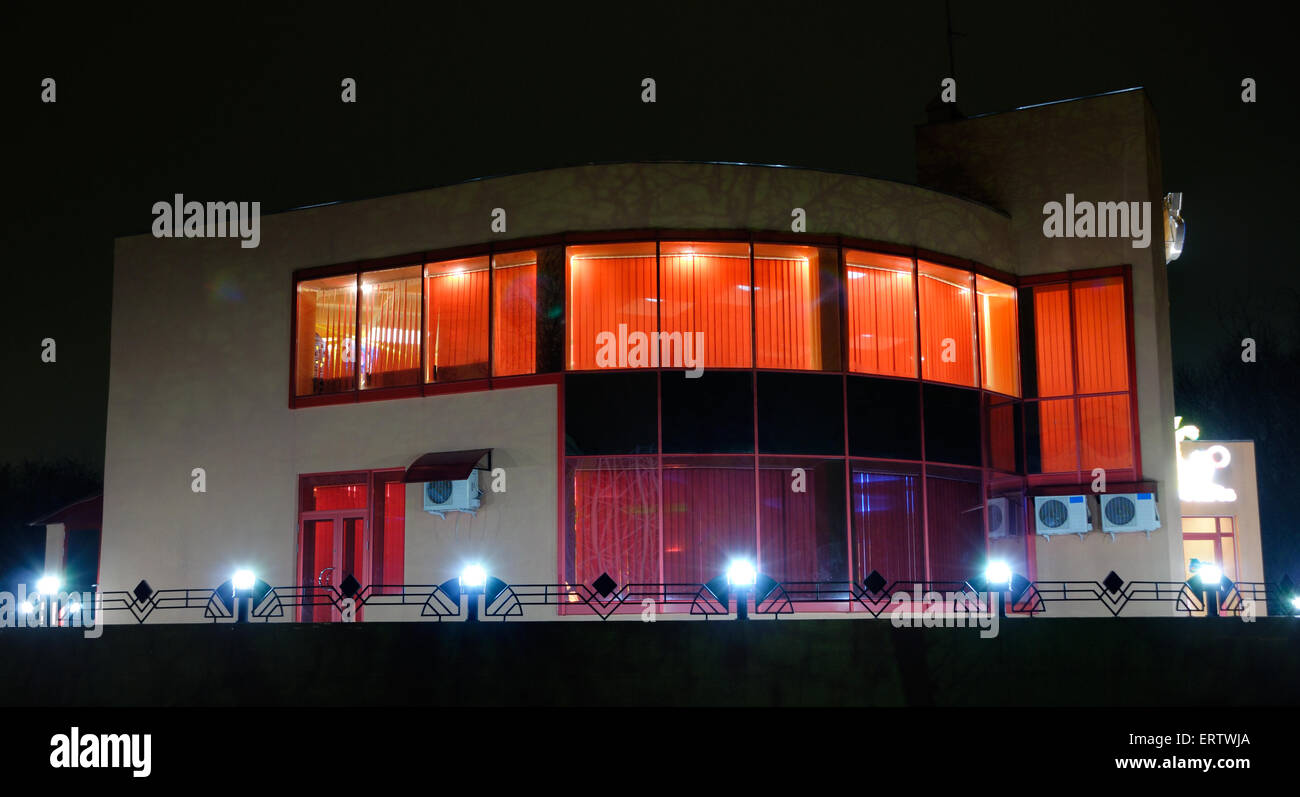Exterior of a building with red windows at night Stock Photo - Alamy
