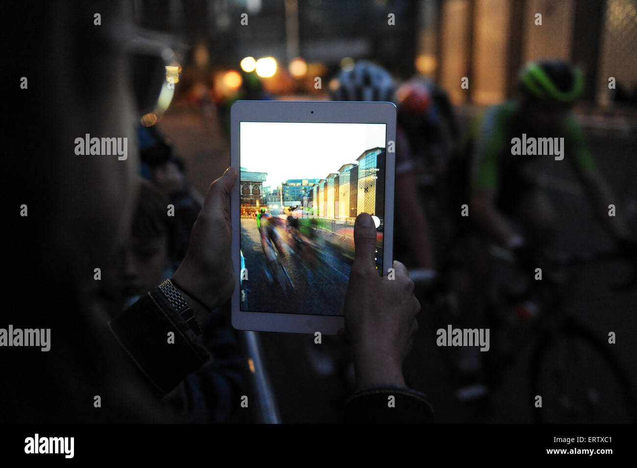 Spectator photographing the elite mens cycling race at Smithfield ...