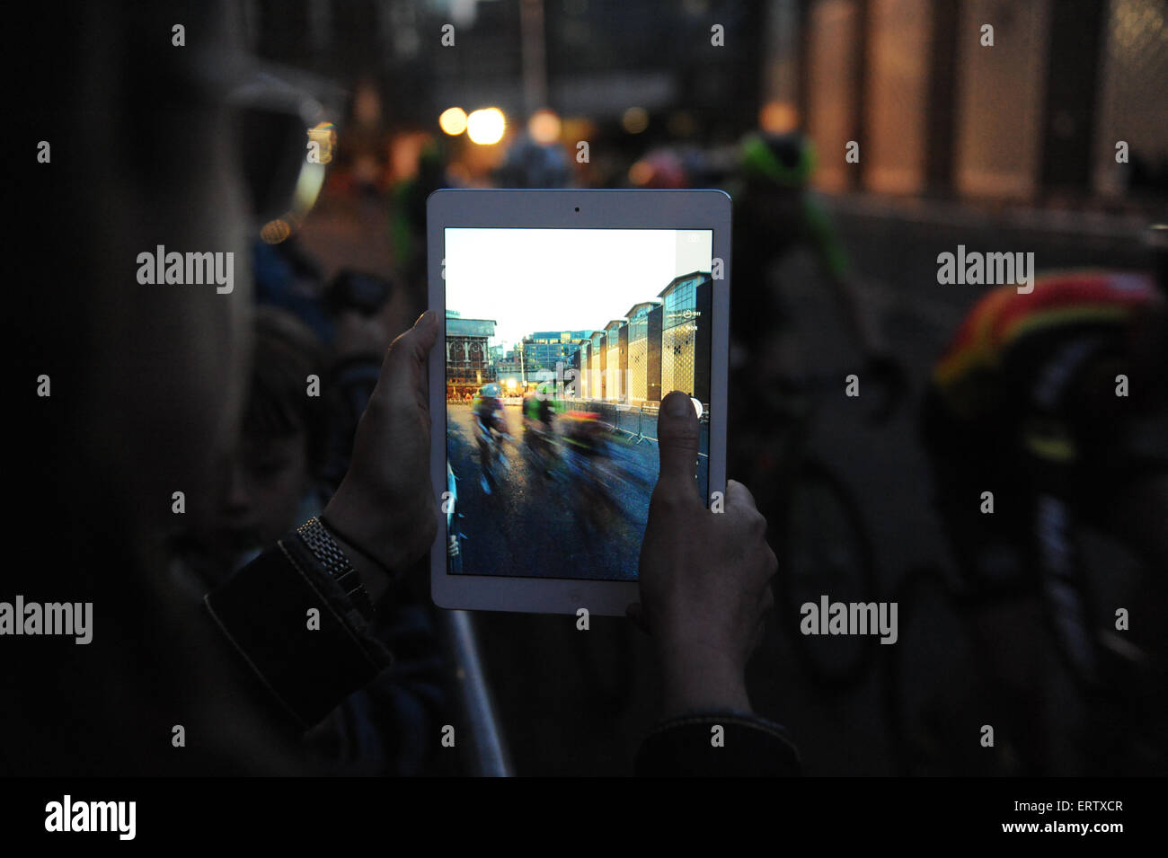 Spectator photographing the elite mens cycling race at Smithfield ...