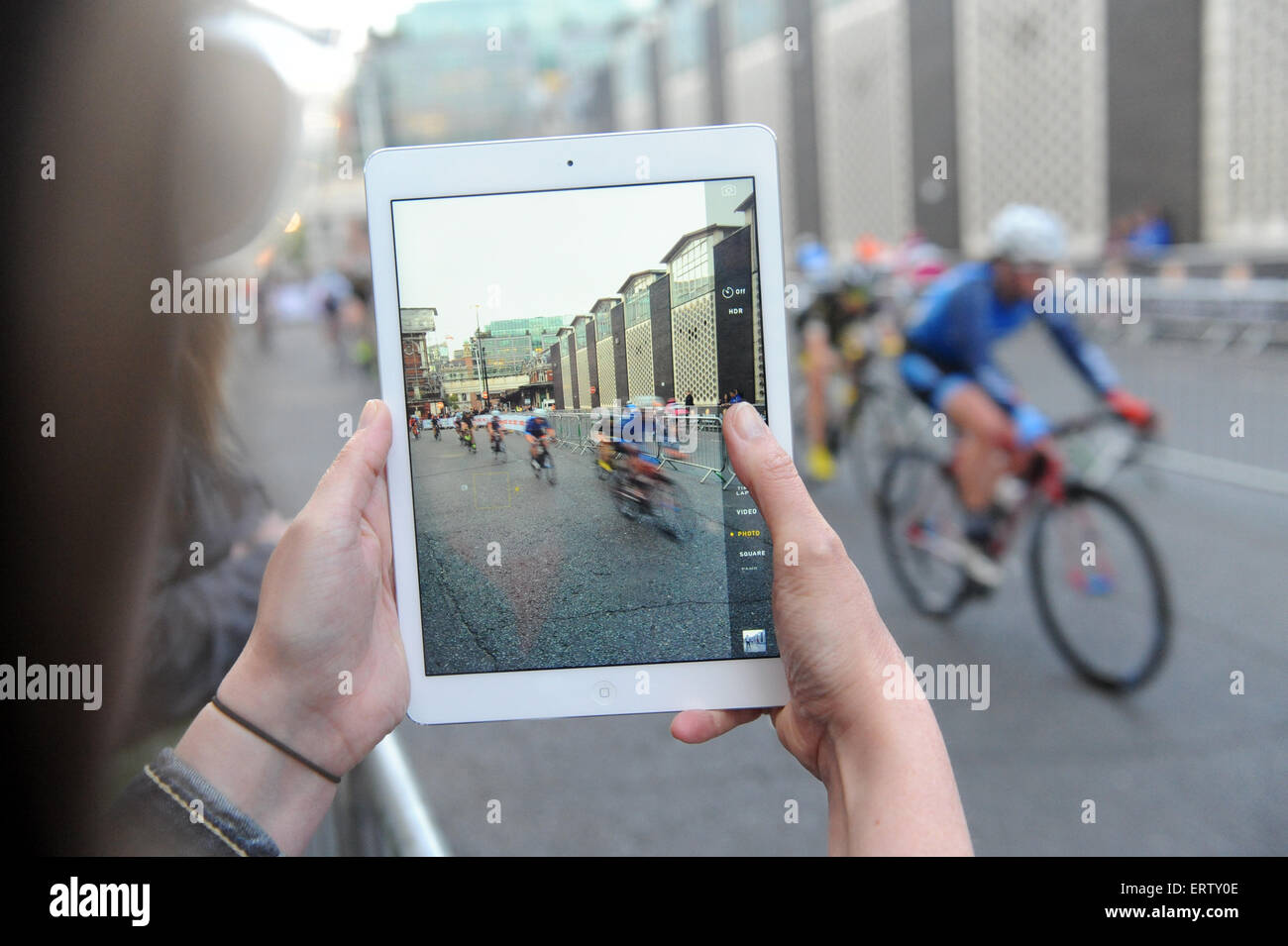 Spectator photographing the elite mens cycling race at Smithfield ...
