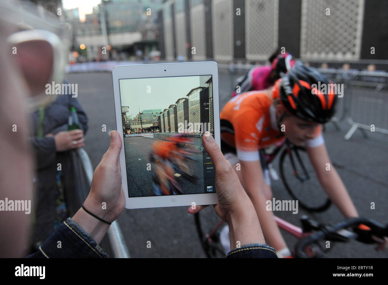 Spectator photographing the elite mens cycling race at Smithfield ...