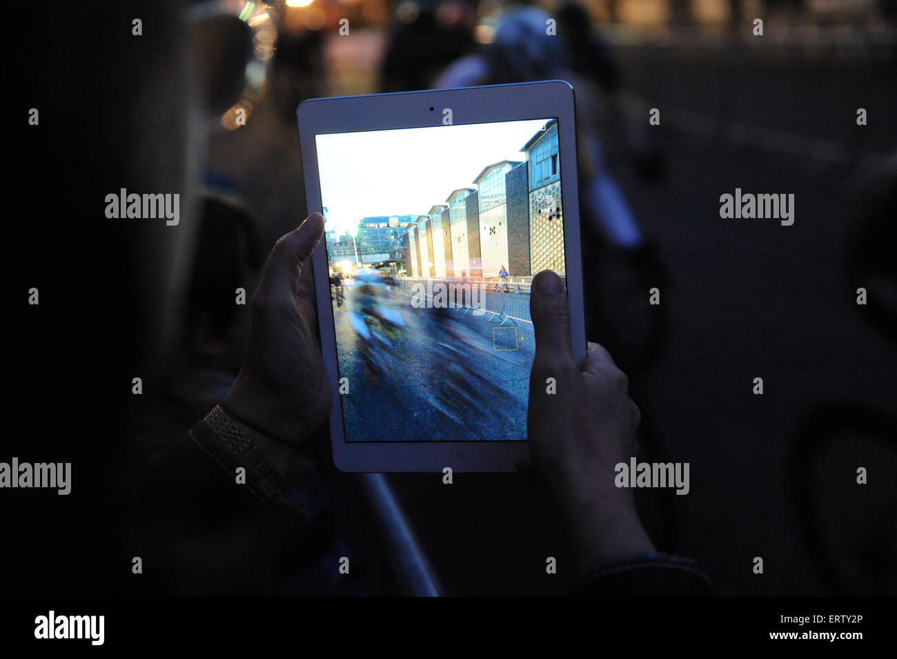 Spectator photographing the elite mens cycling race at Smithfield ...