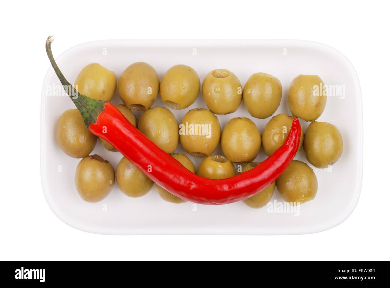 Green olives and chili pepper on a plate isolated Stock Photo - Alamy