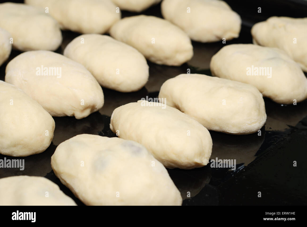 Rolls from the dough on a dripping pan before bake Stock Photo - Alamy