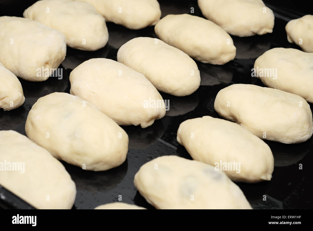 Rolls from the dough on a dripping pan before bake Stock Photo - Alamy