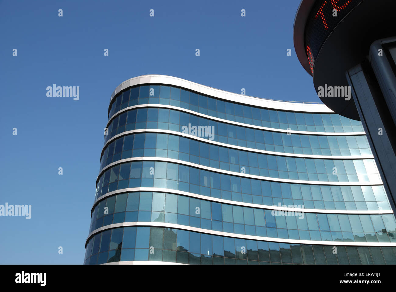 The blue facade of a modern building with running illuminated signs ...