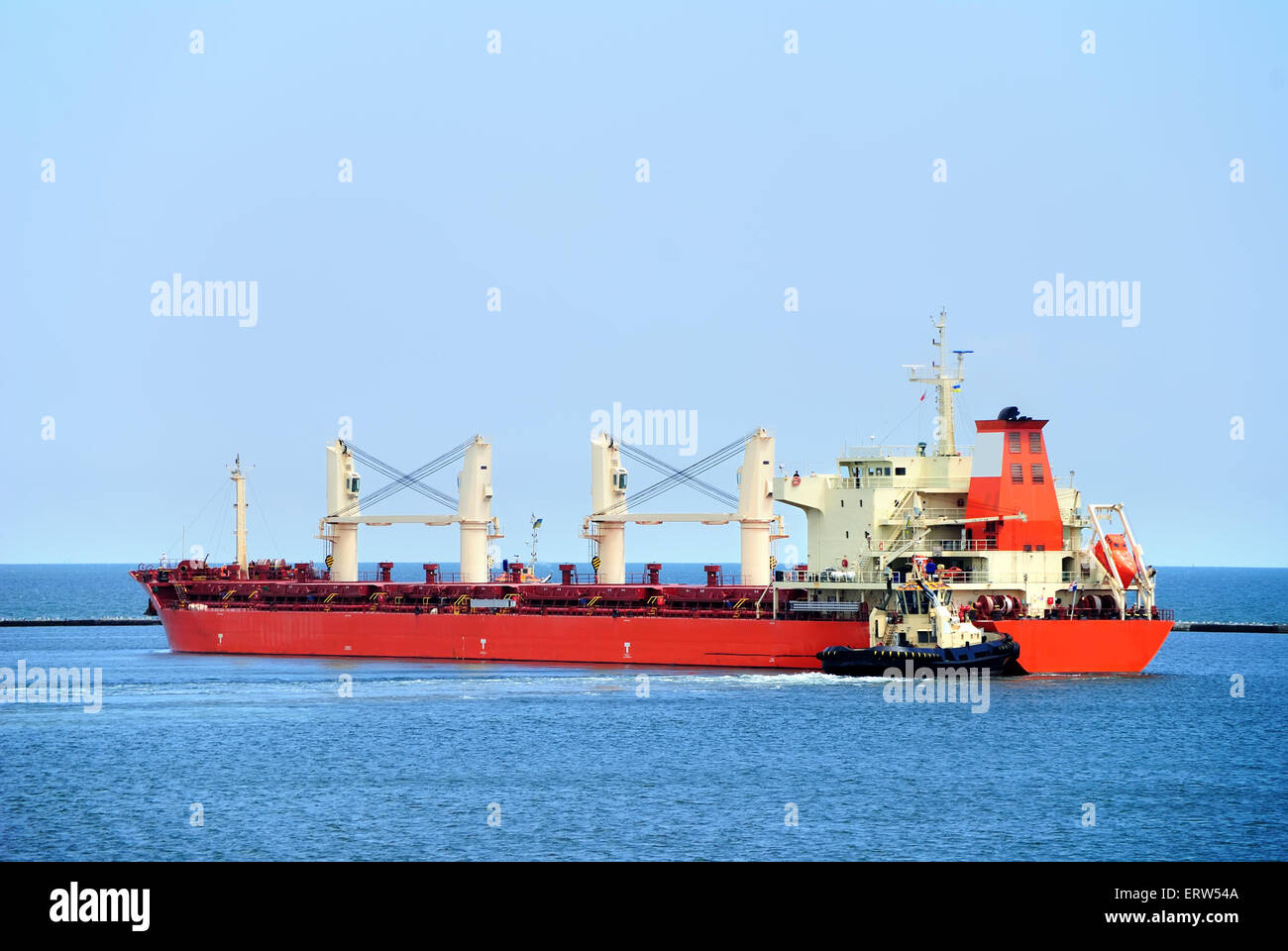 Tug boat helps to maneuver the ship in port Stock Photo - Alamy