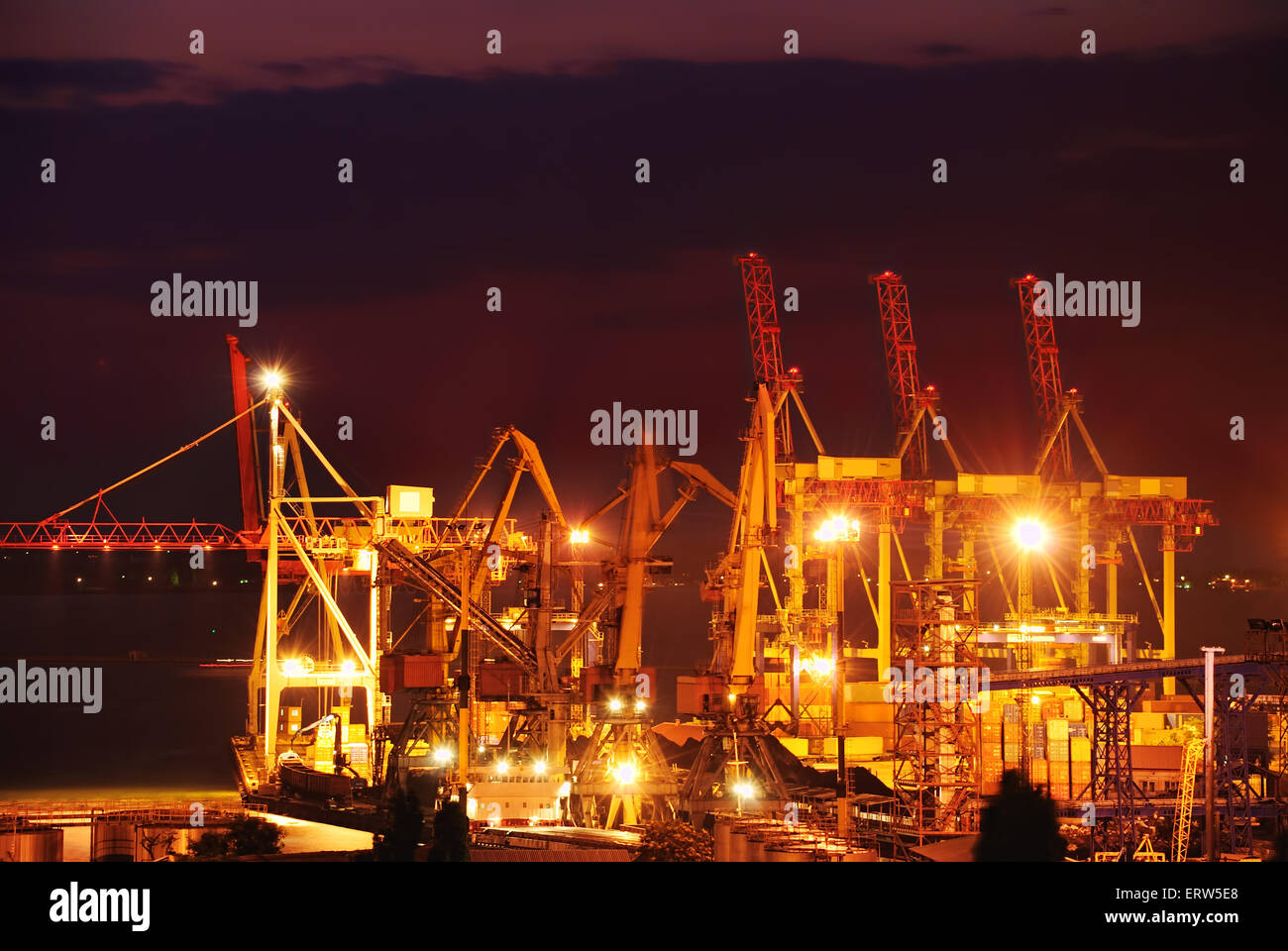 Port warehouse with cargoes and containers at night Stock Photo - Alamy