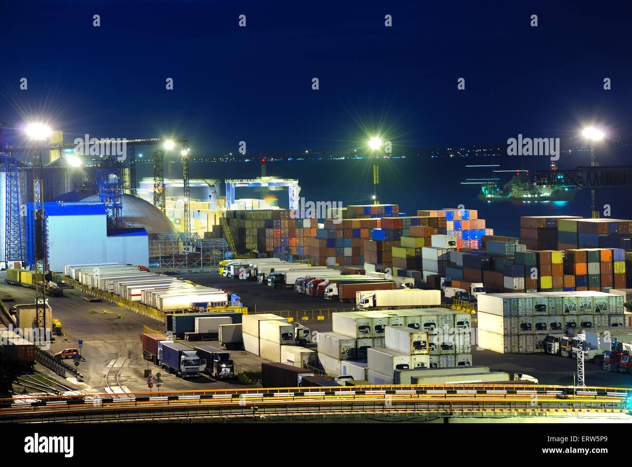 Port warehouse with cargoes and containers at night Stock Photo - Alamy
