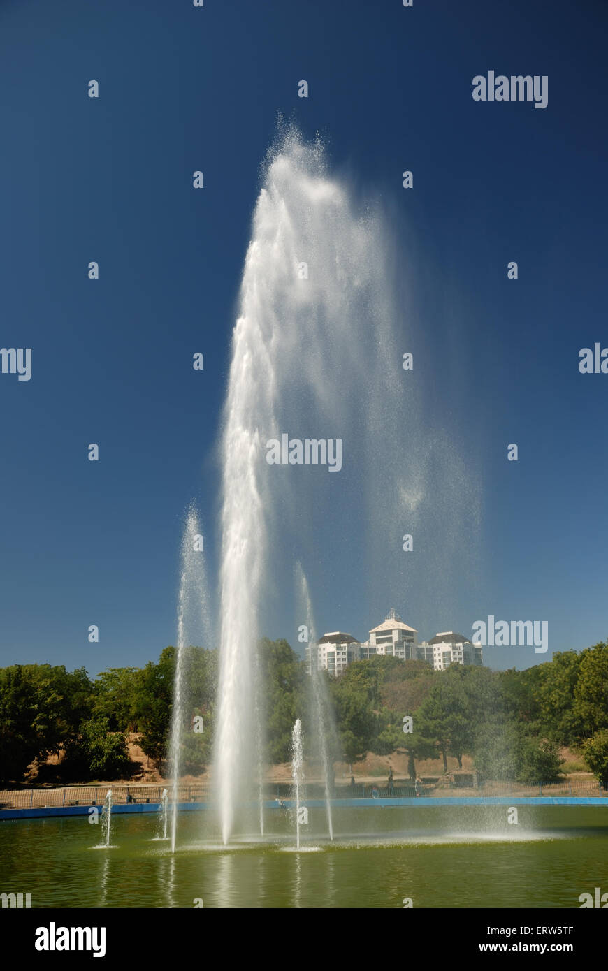 Landscape with a high fountain in city park Stock Photo - Alamy