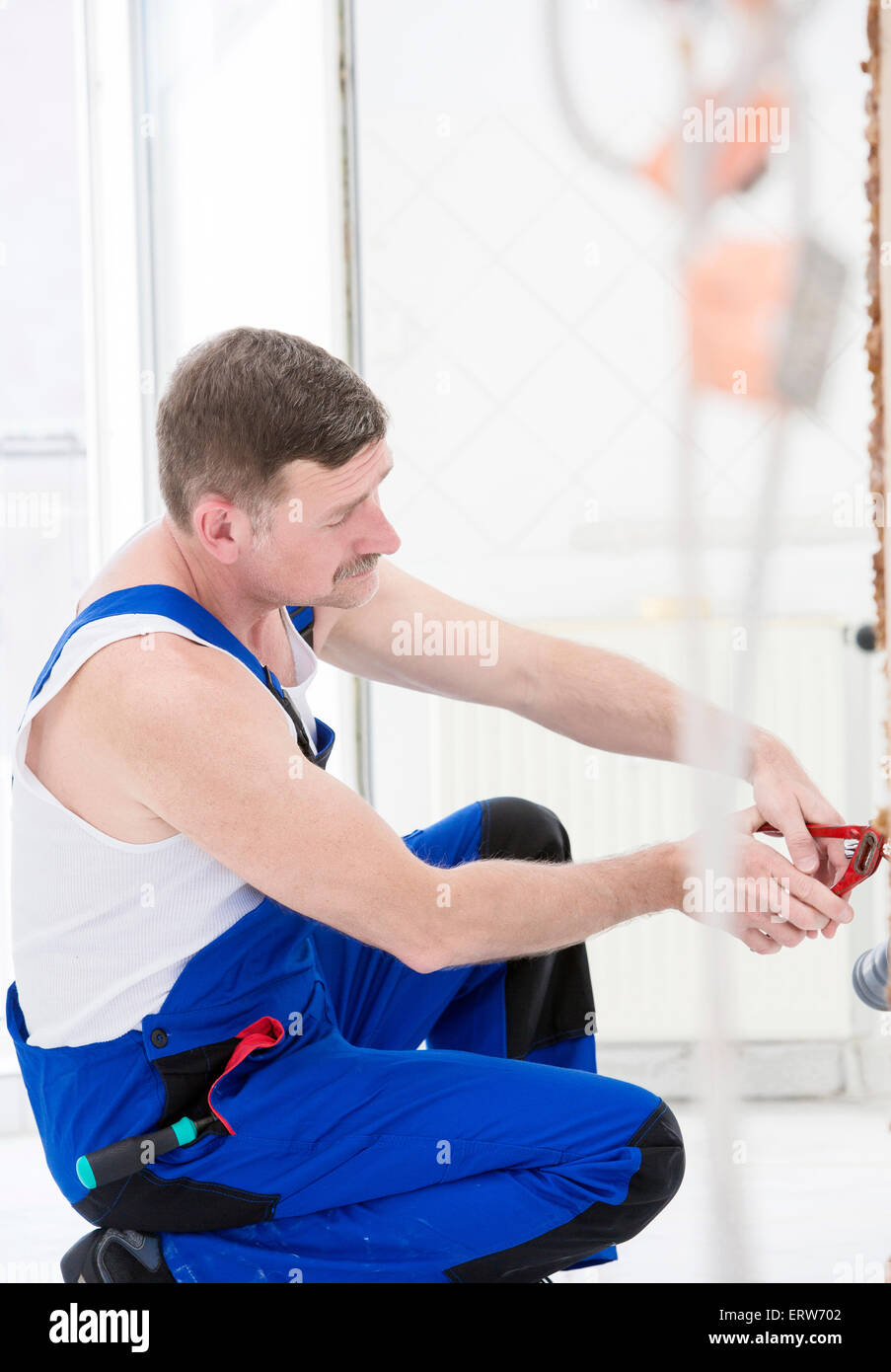a repairman working on plumbing in an apartment Stock Photo - Alamy