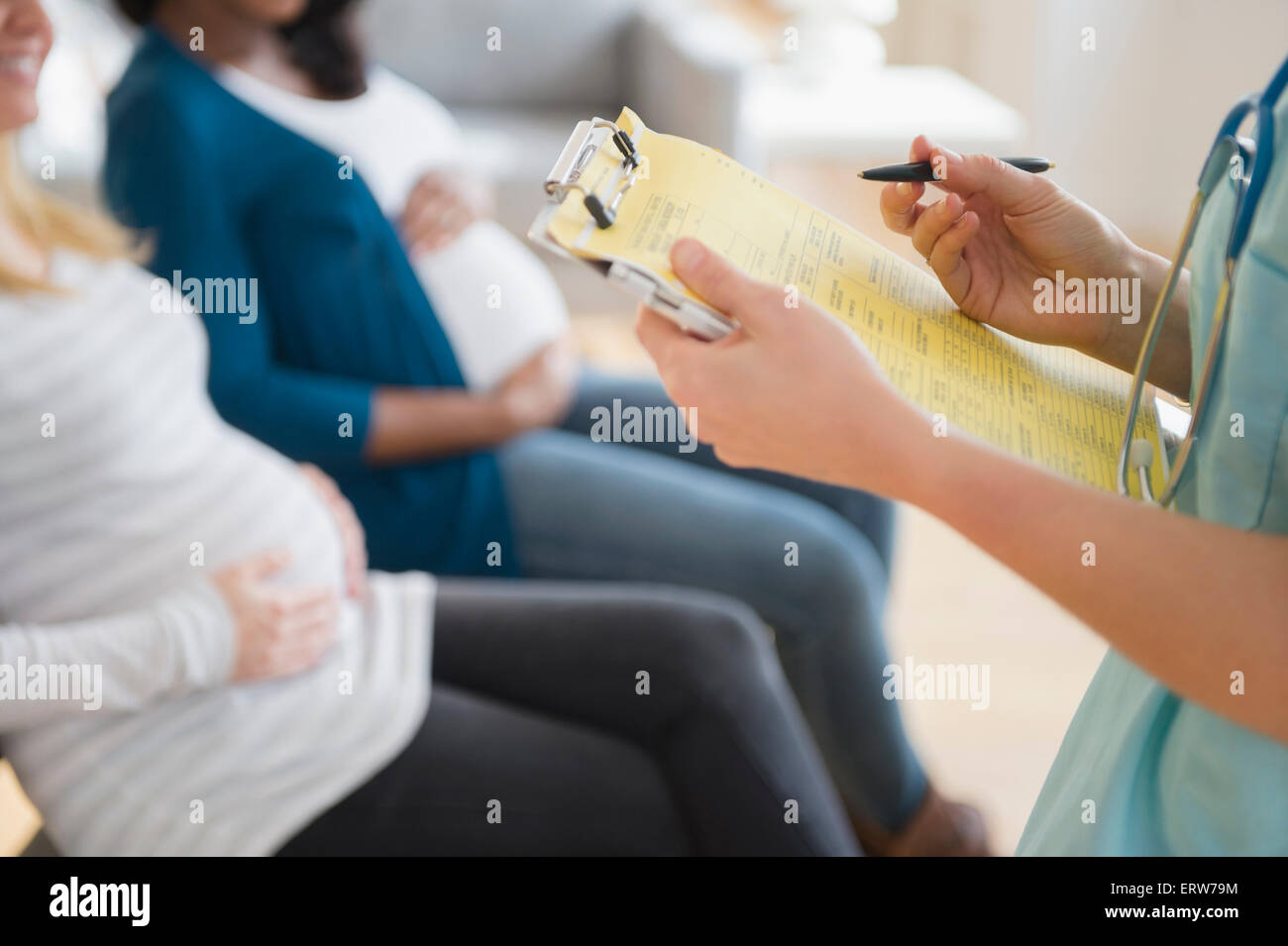 Nurse marking medical chart near pregnant women Stock Photo - Alamy