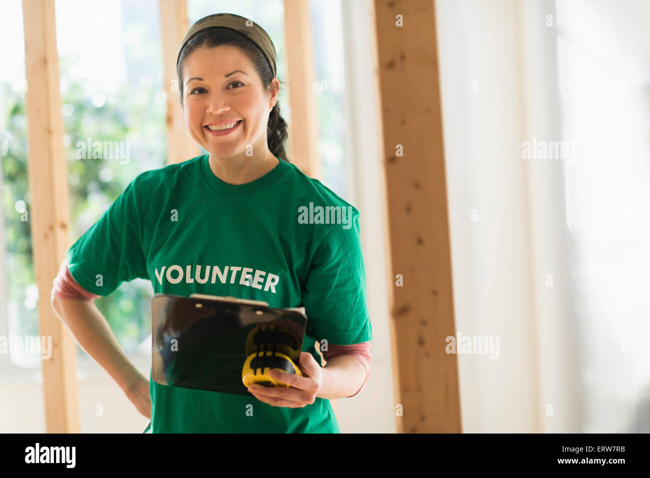 Mixed race volunteer helping build house Stock Photo - Alamy