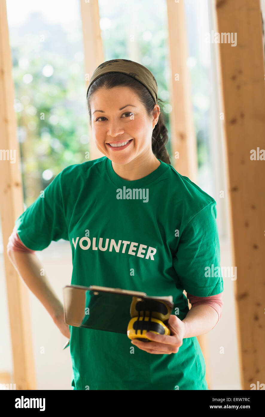Mixed race volunteer helping build house Stock Photo - Alamy