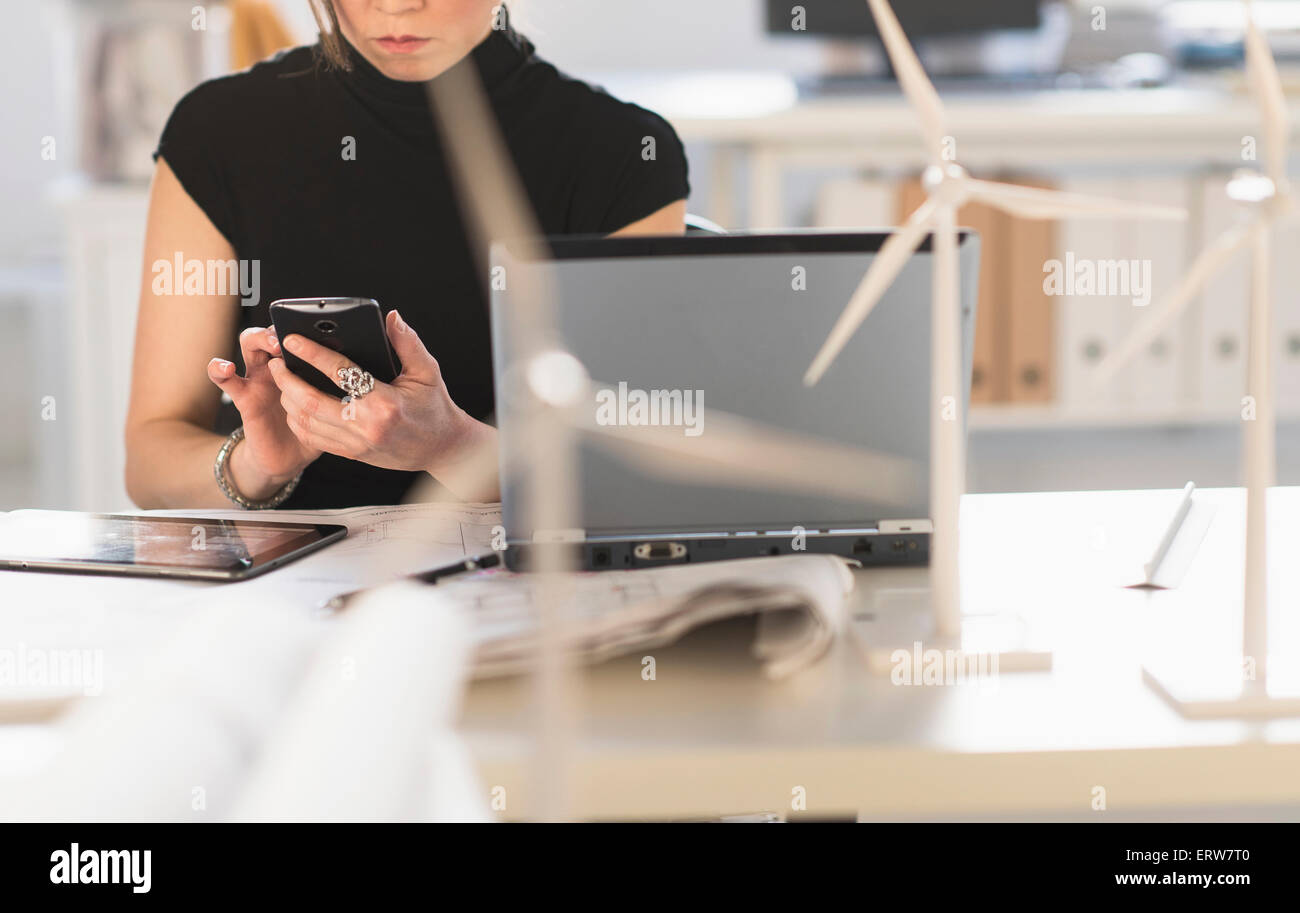Mixed race architect with windmill models using cell phone Stock Photo ...