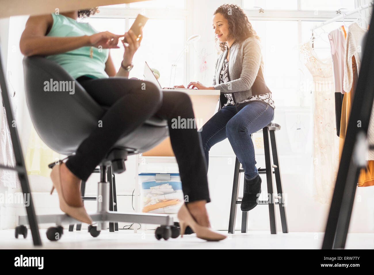 View underneath desk of businesswomen working in office Stock Photo - Alamy