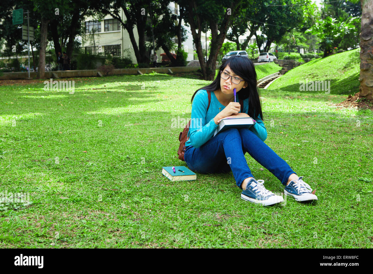 College student hold books, writing, posing and studying outdoor in ...